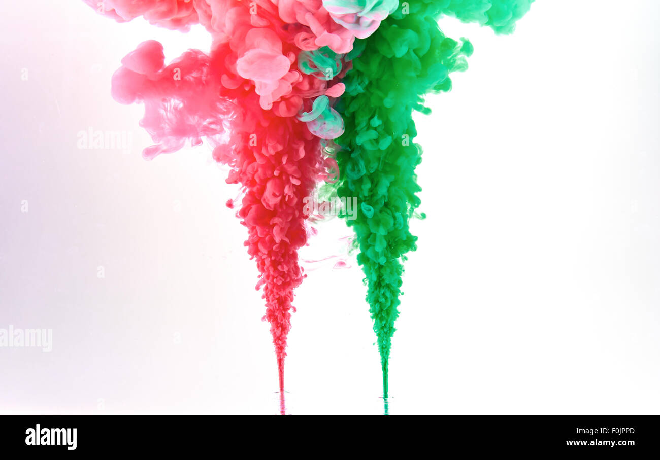 Red and green ink making clouds in water Stock Photo - Alamy