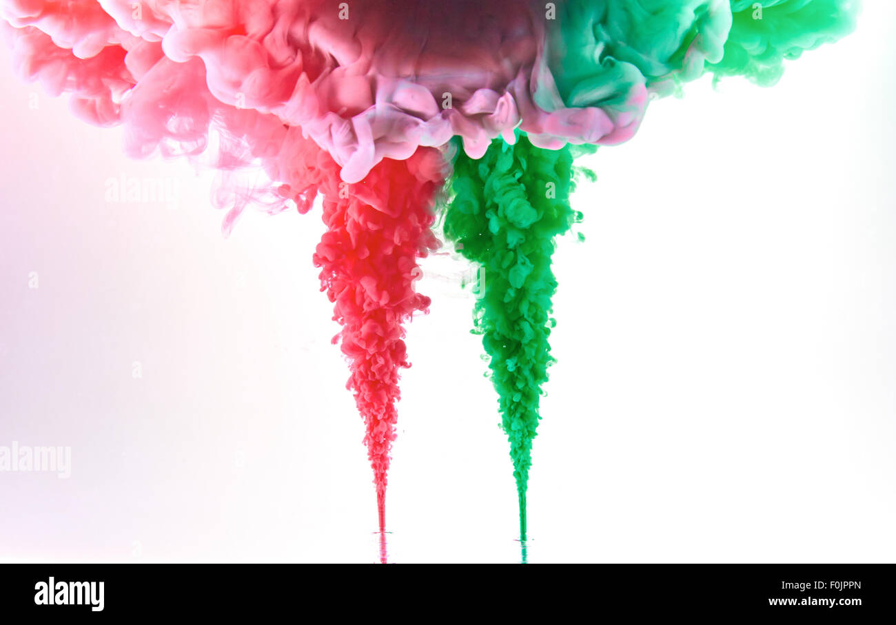 Red and green ink making clouds in water Stock Photo - Alamy