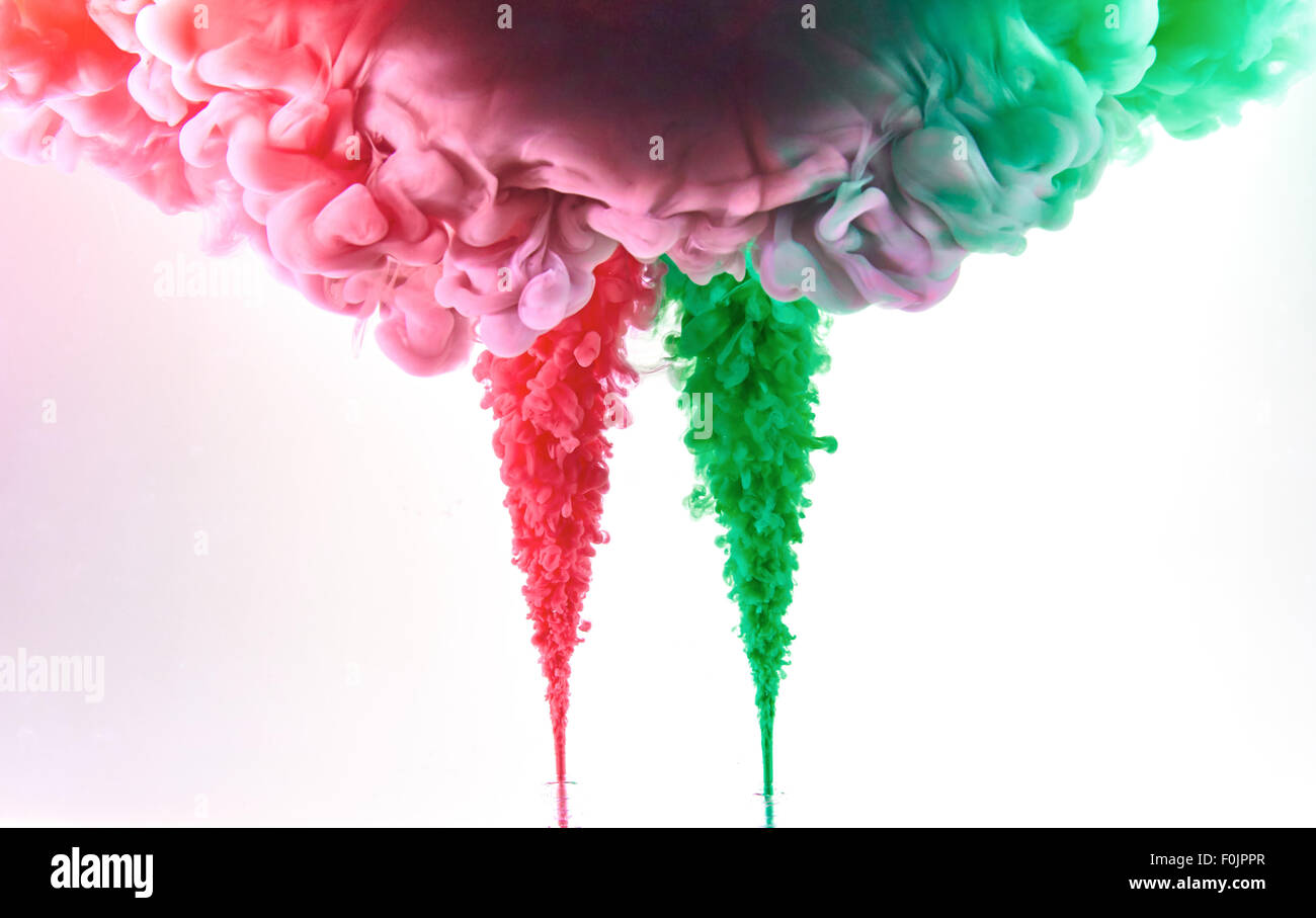 Red and green ink making clouds in water Stock Photo - Alamy