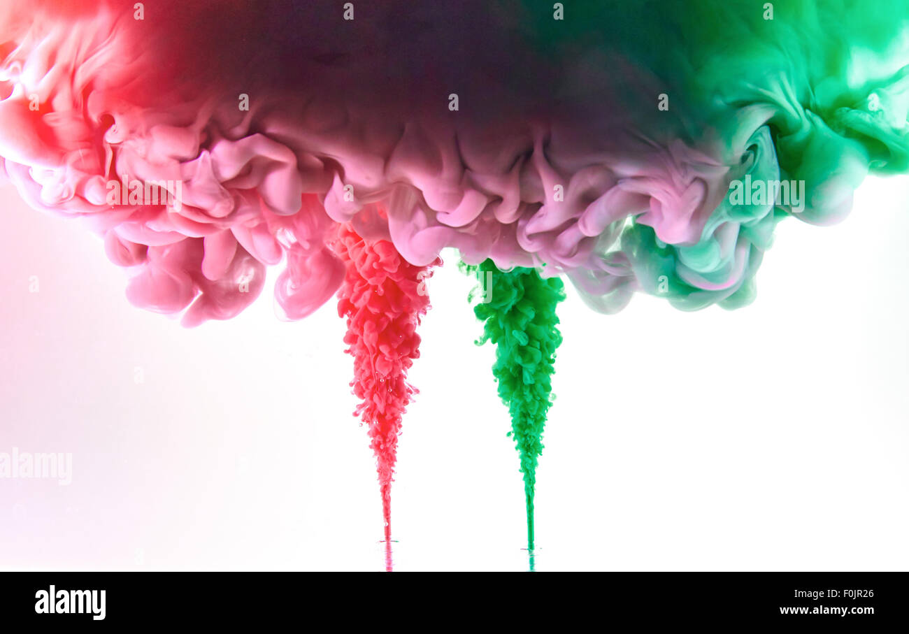 Red and green ink making clouds in water Stock Photo - Alamy
