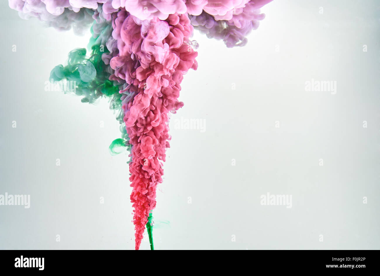 Red and green ink making clouds in water Stock Photo - Alamy