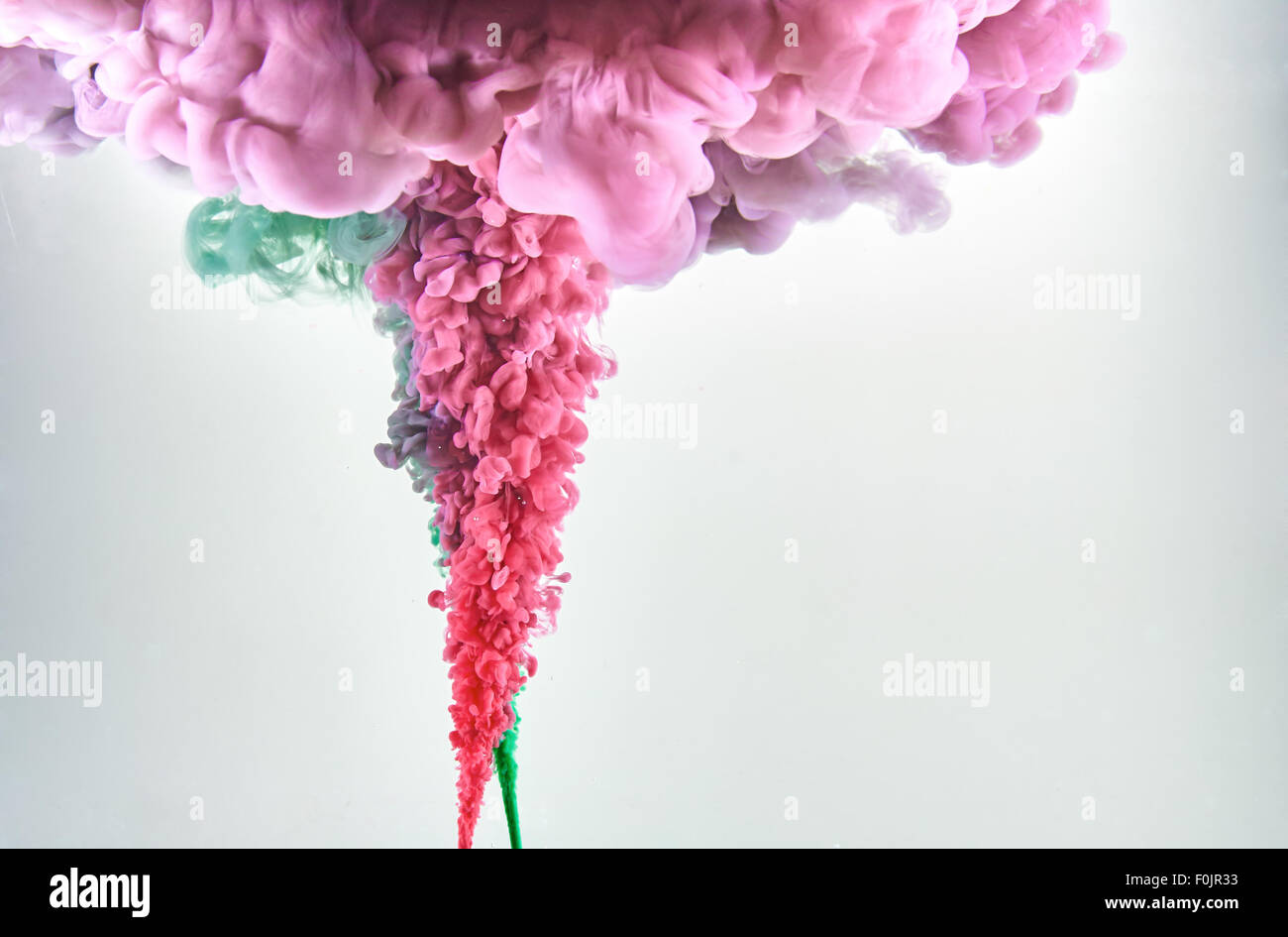Red and green ink making clouds in water Stock Photo - Alamy