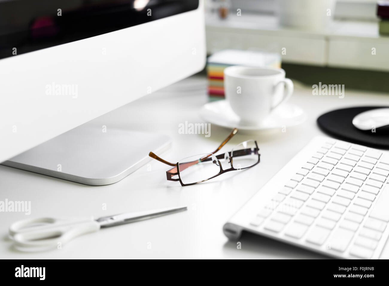 Office workplace with computer on white table. Focus on glasses Stock ...