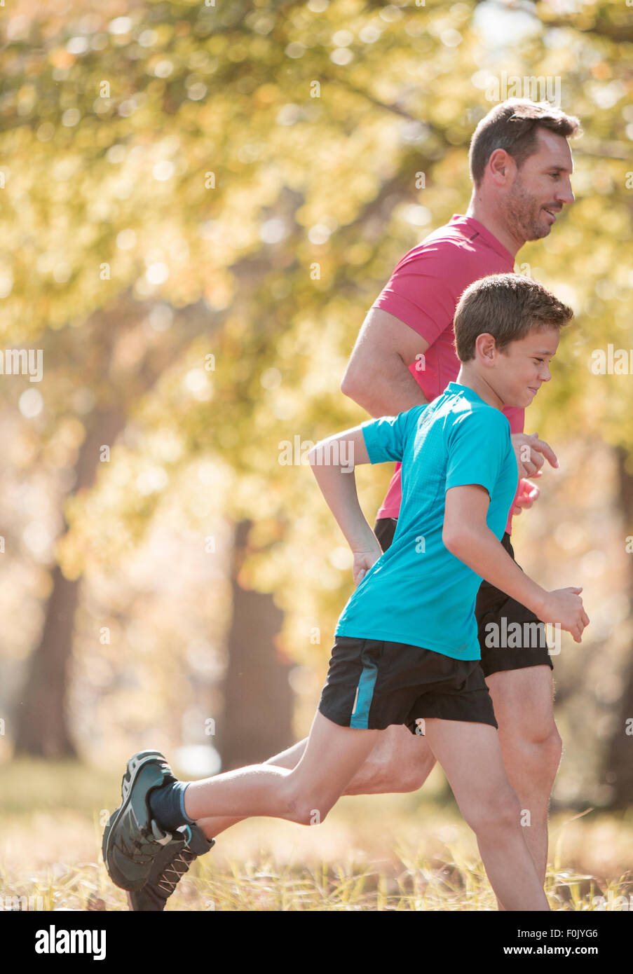 Father and son jogging in park Stock Photo - Alamy