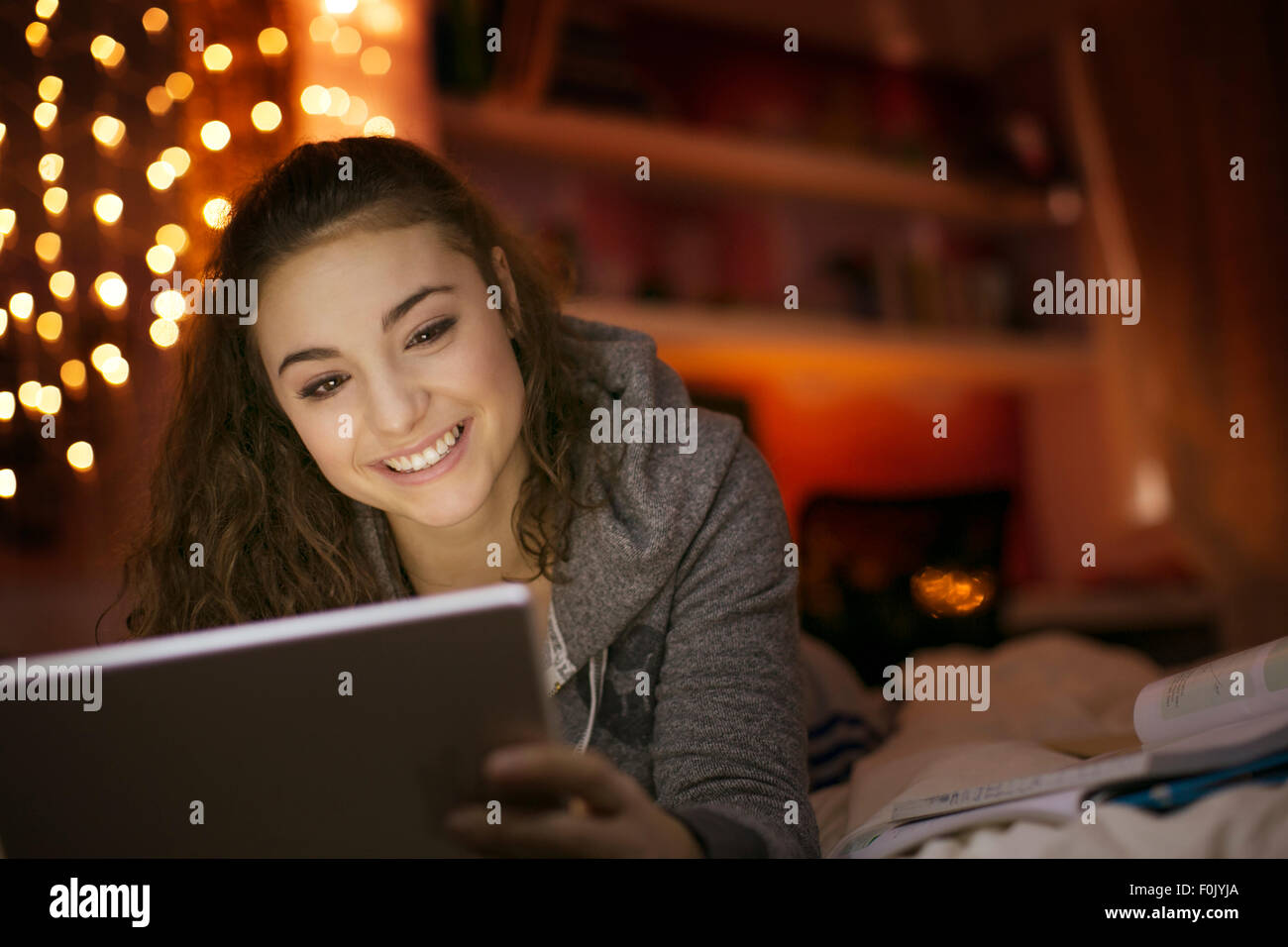 Smiling teenage girl using digital tablet on bed Stock Photo - Alamy