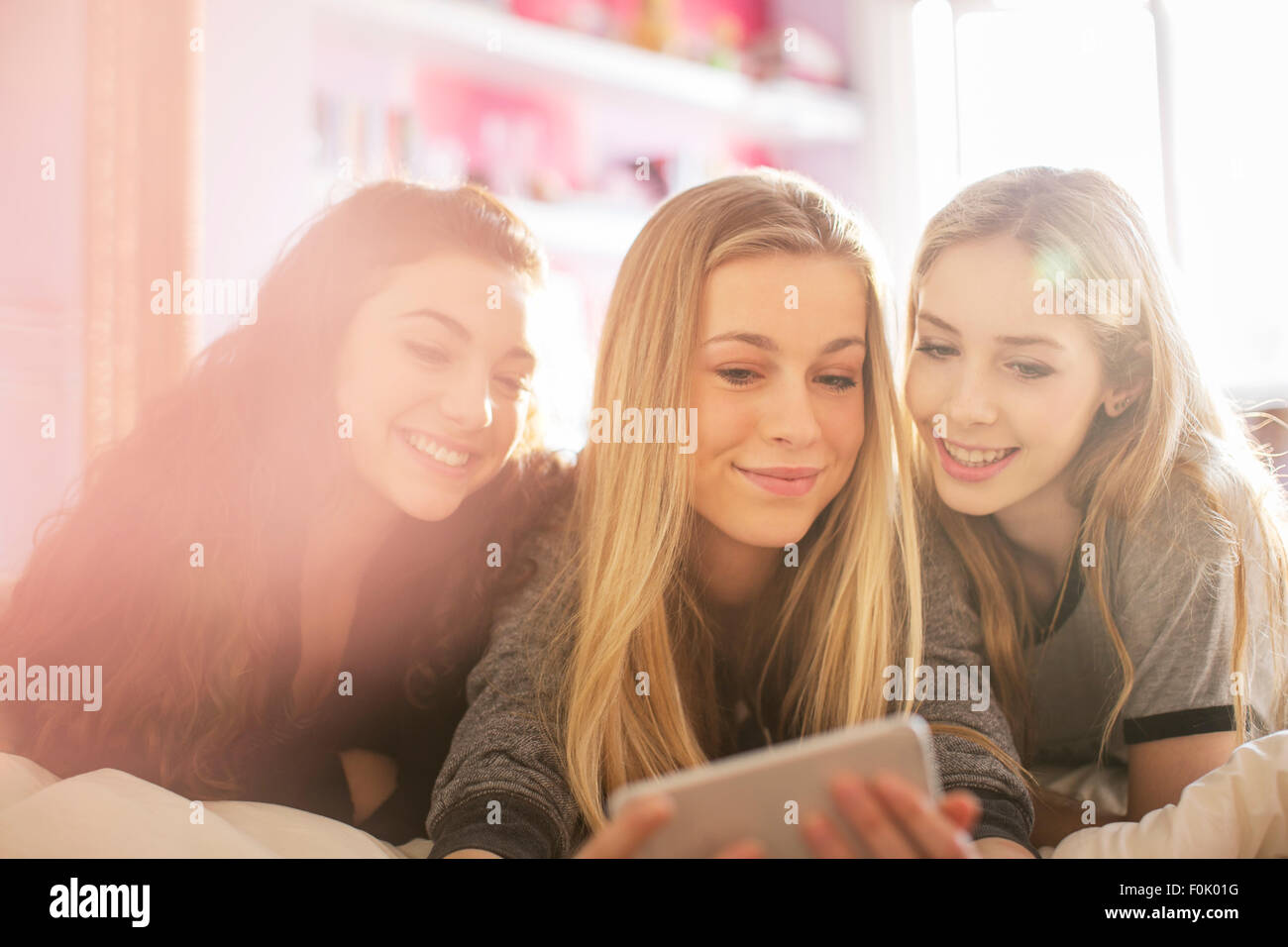Teenage girls texting with cell phone on bed Stock Photo - Alamy