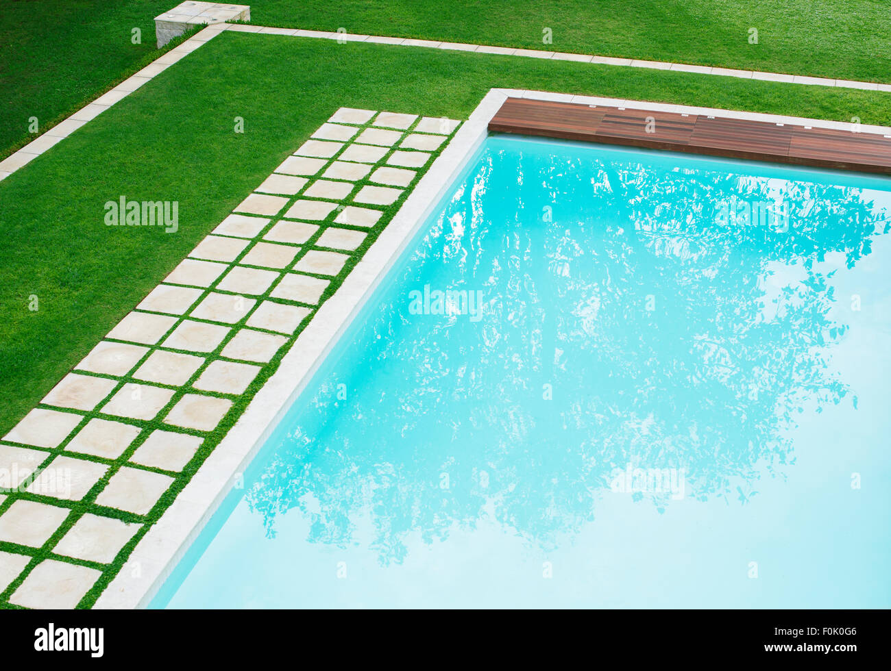 Paving stones in a row along swimming pool in backyard Stock Photo - Alamy