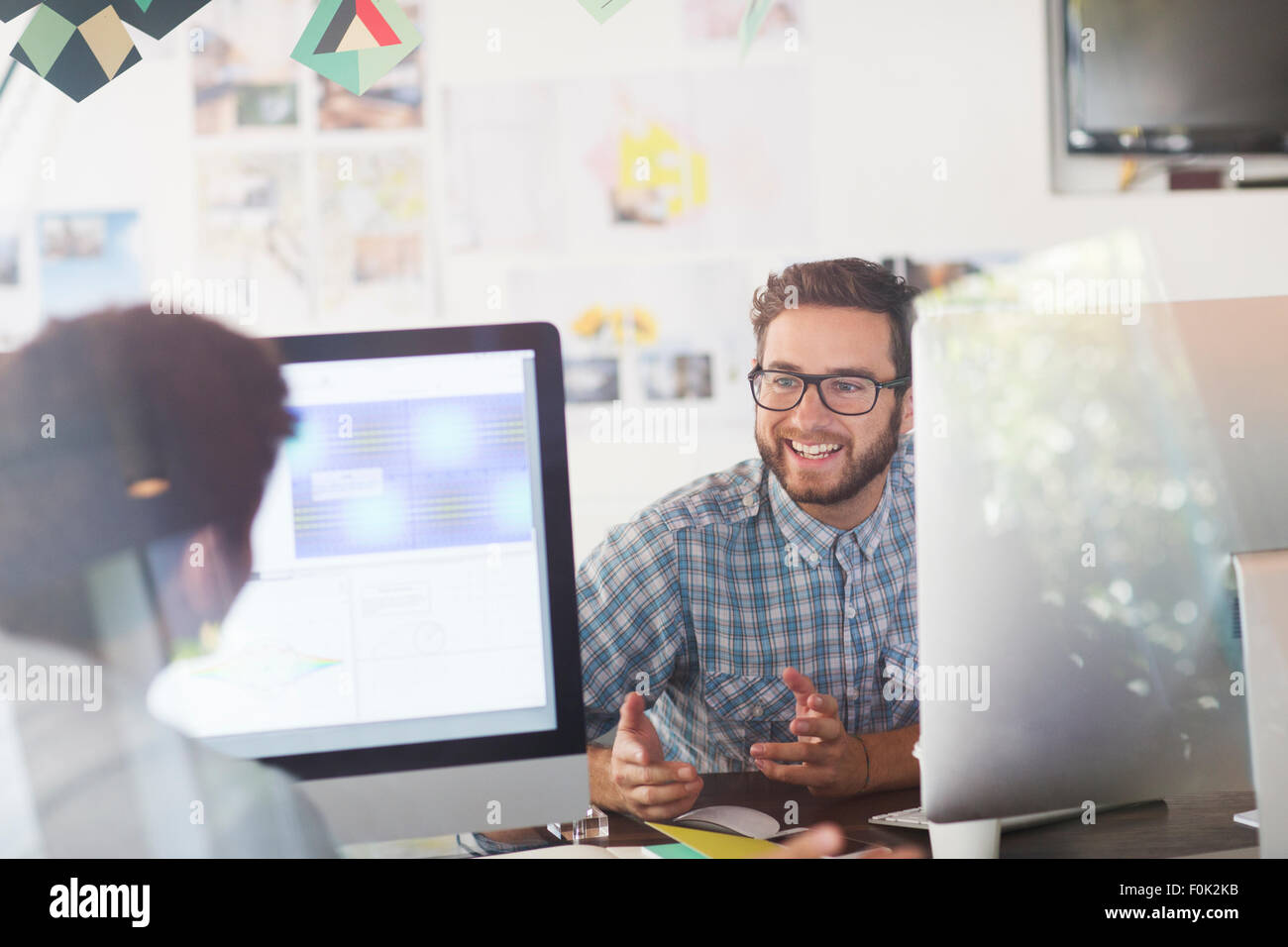 Creative businessmen talking at computer in office Stock Photo - Alamy