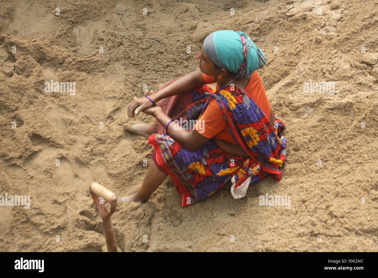 A woman taking rest after finished work. She carries heavy loads of ...