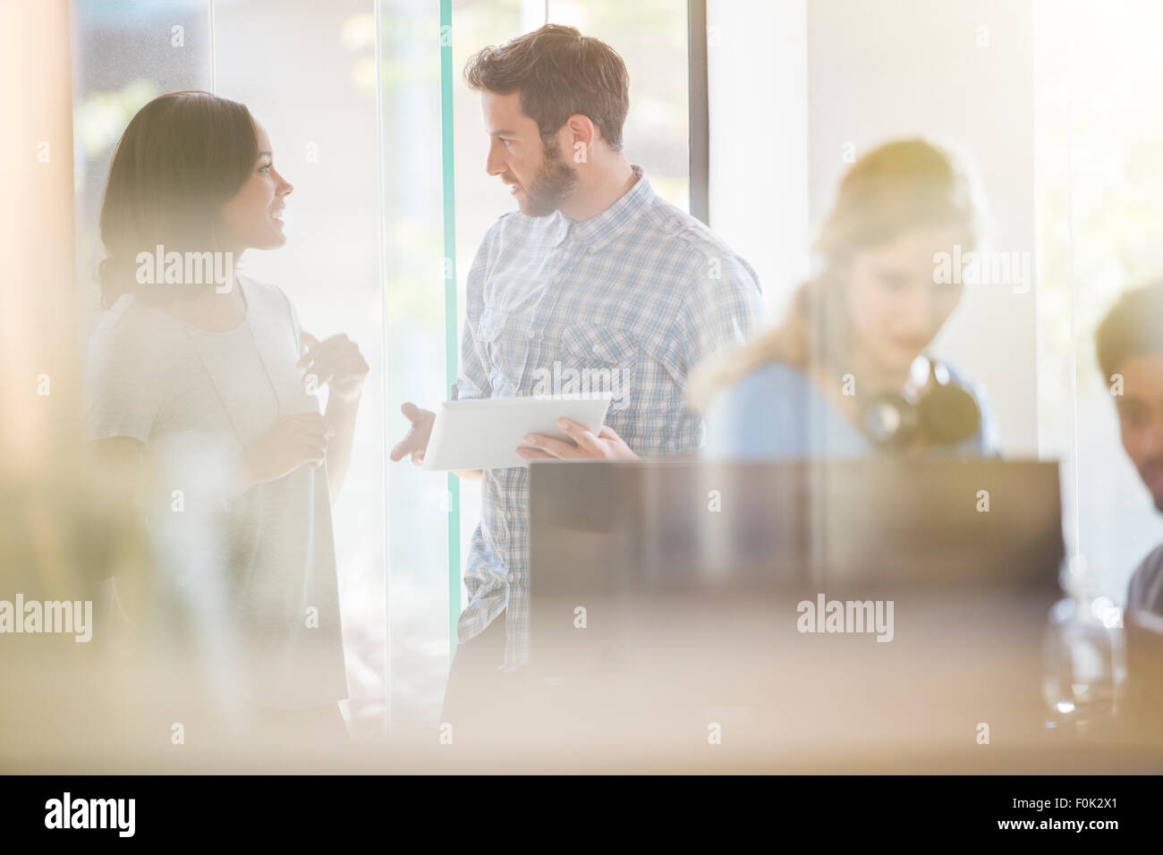 Business people with digital tablet talking in office Stock Photo - Alamy