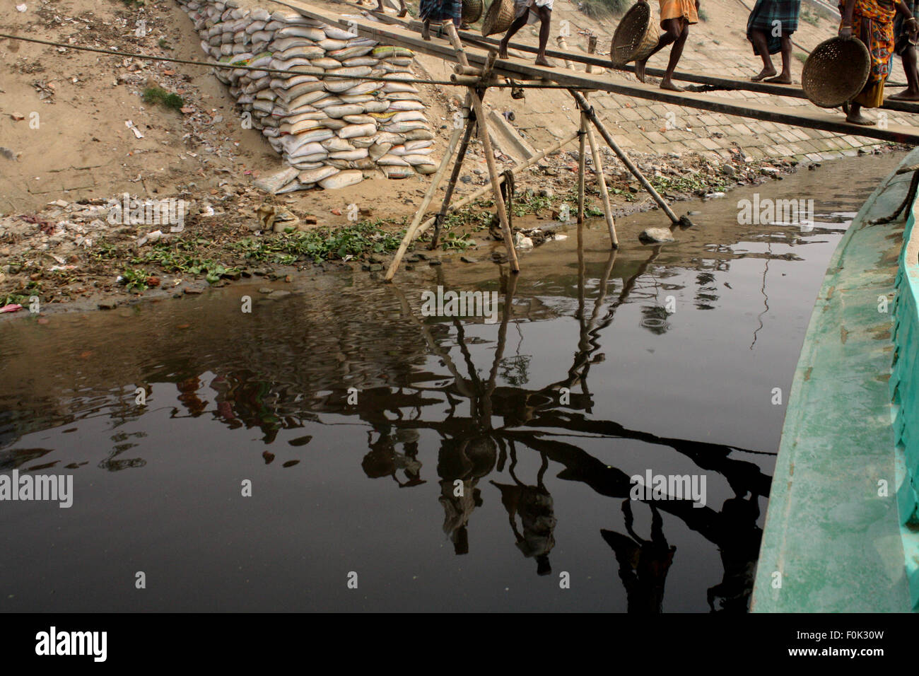 Male and female laborers carry heavy loads of sand balanced on their ...