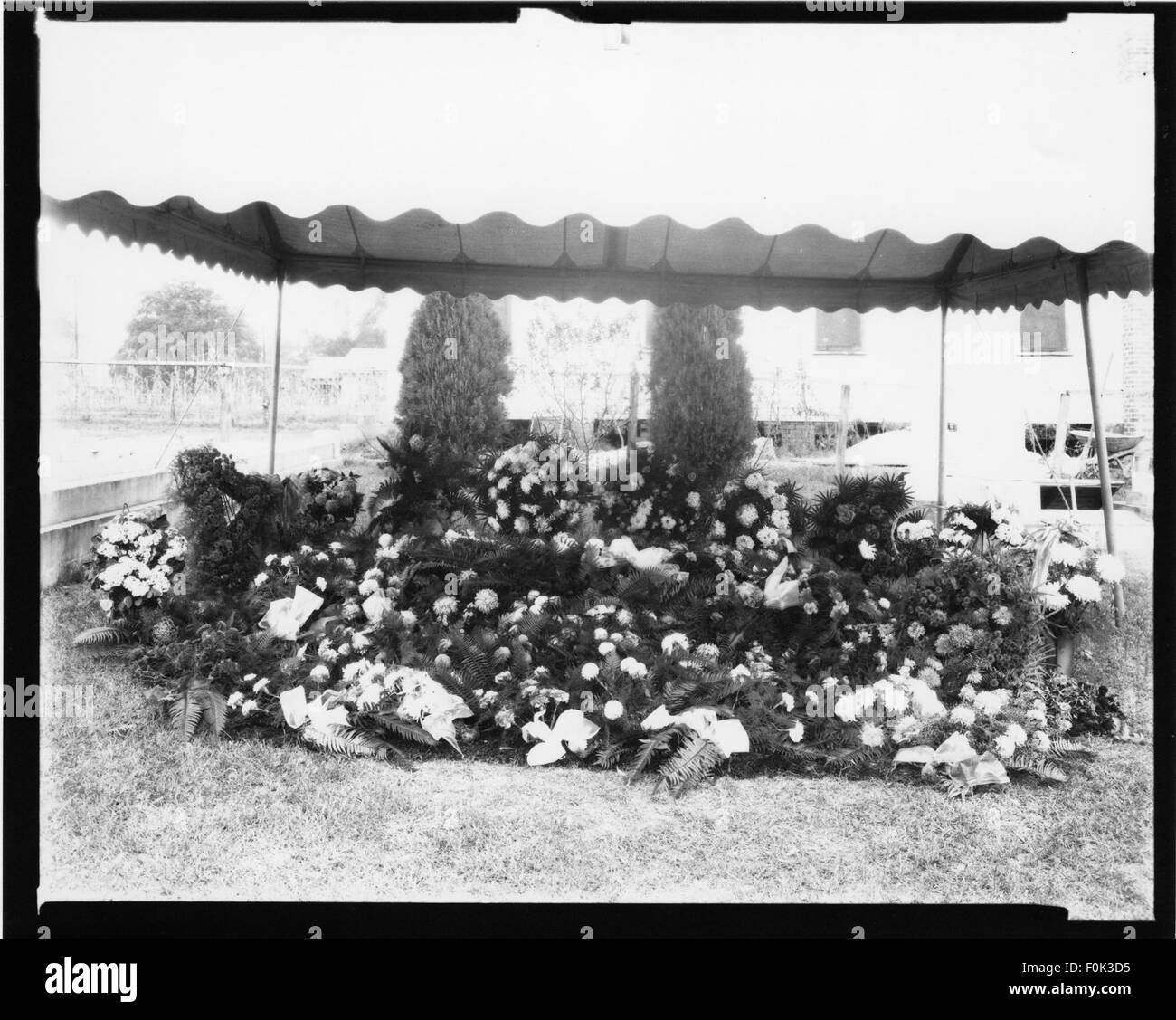 A photograph of a funeral gravesite in a cemetery, highlighting the ...