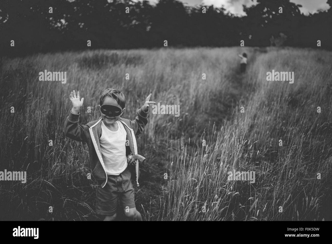 A young boy in a mask with a toy gun in a field Stock Photo - Alamy