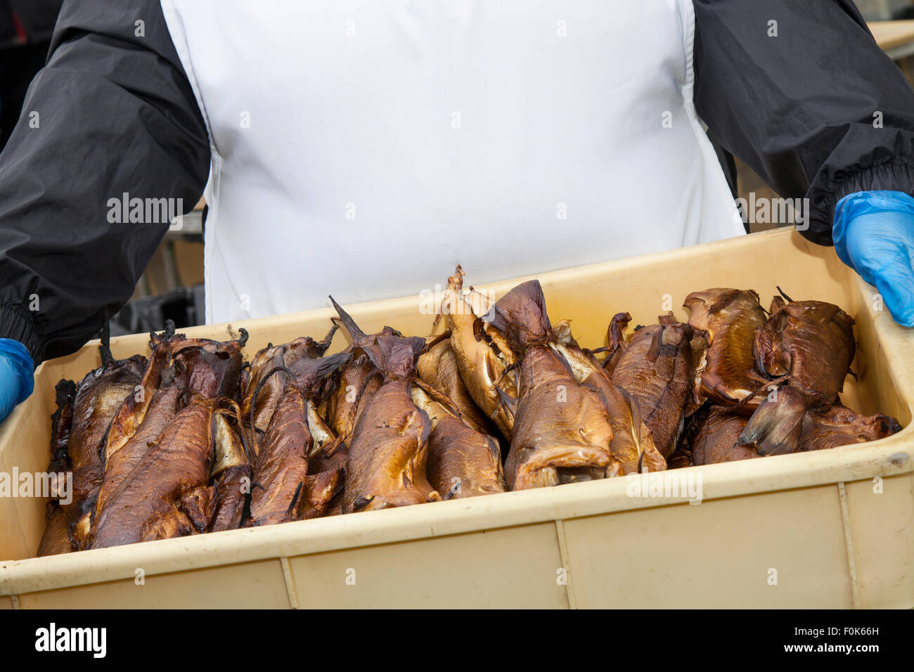 Woman holding tray. Cooked Haddock fish Smokies, smoked preserved ...