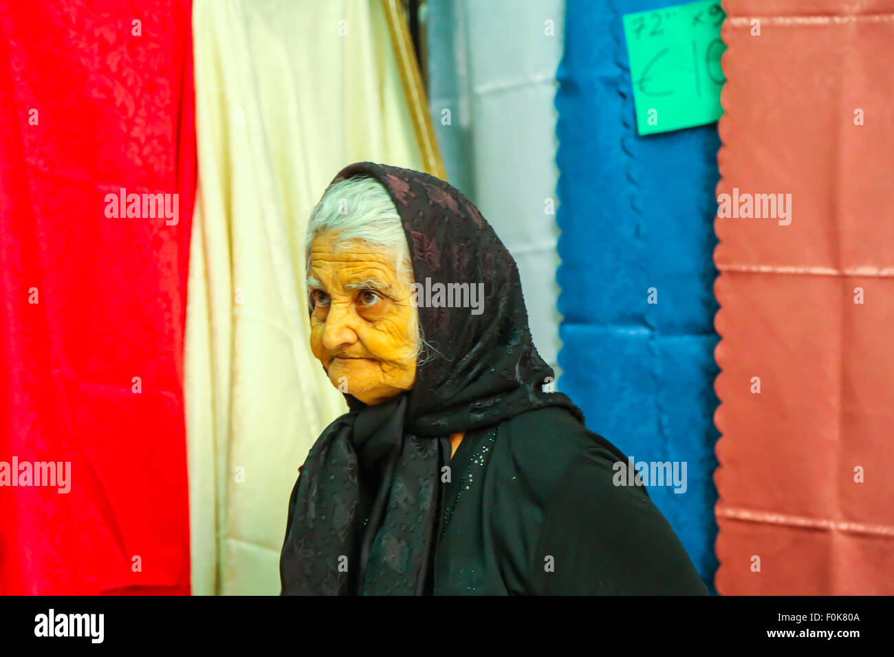 Lady linen market stall holder in the market in Paphos Old Town, Cyprus ...