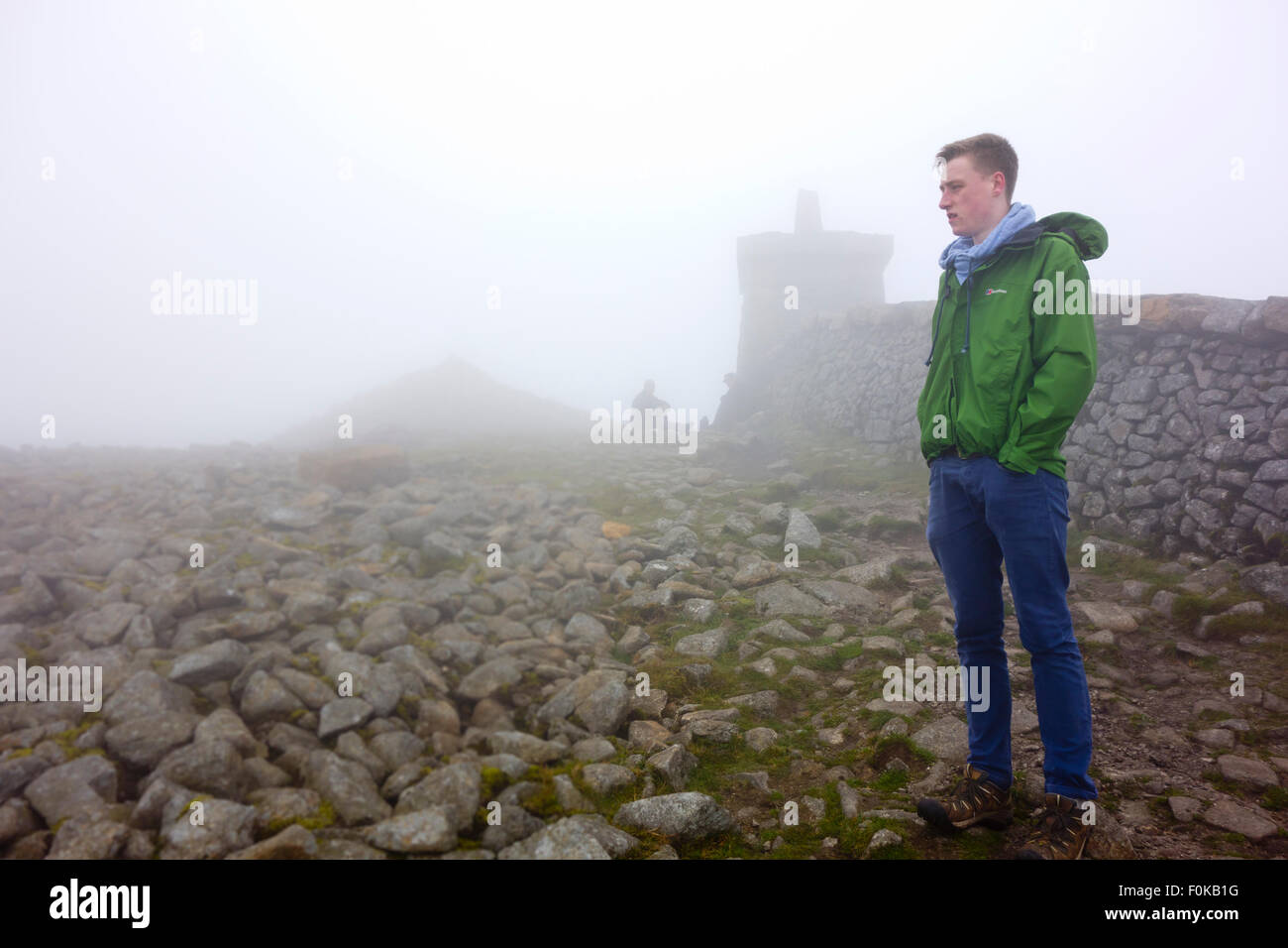 Slieve Donard summit in the mist with teenage male walker Stock Photo ...
