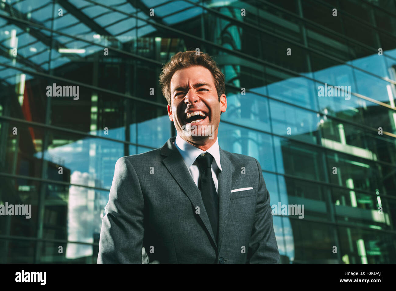 Laughing businessman outside office building Stock Photo - Alamy