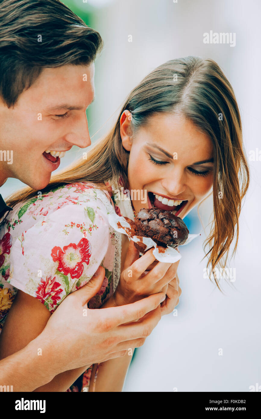 Happy young couple eating chocolate muffin Stock Photo - Alamy