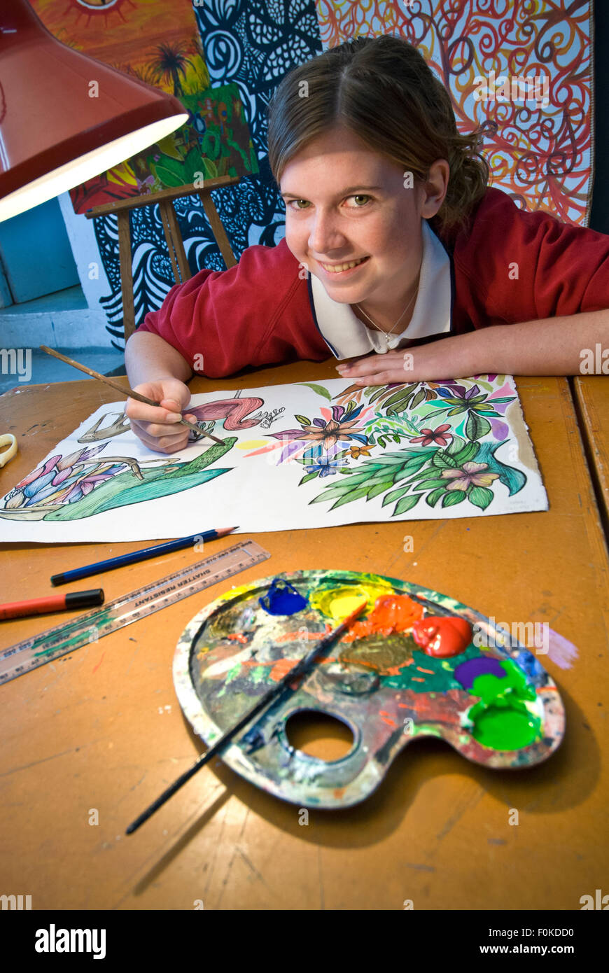 Teenage senior girl student smiles confidently whilst working on her ...