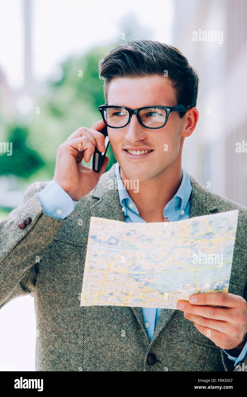 Young man on the phone holding map Stock Photo - Alamy