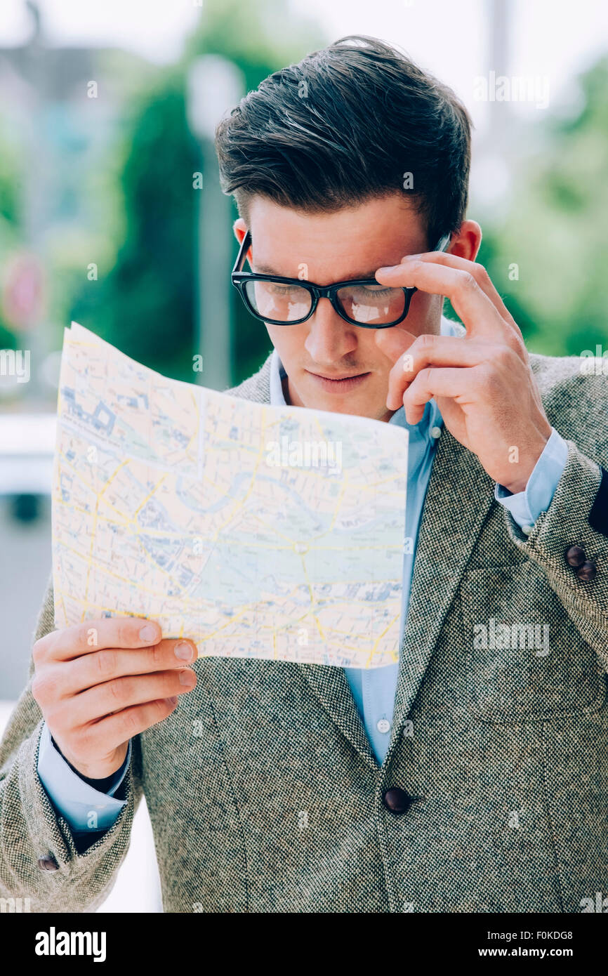Young man reading map Stock Photo - Alamy