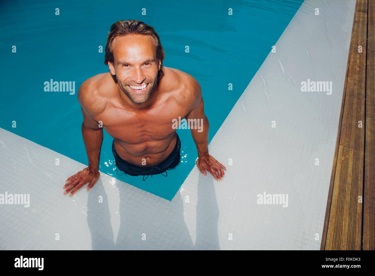 Portrait of smiling man getting out of swimming pool Stock Photo - Alamy