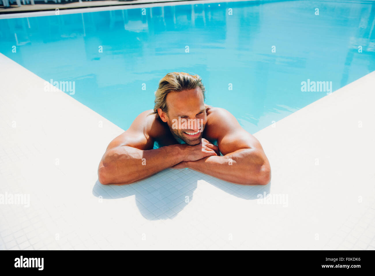 Portrait of smiling man in swimming pool leaning on pool edge Stock ...
