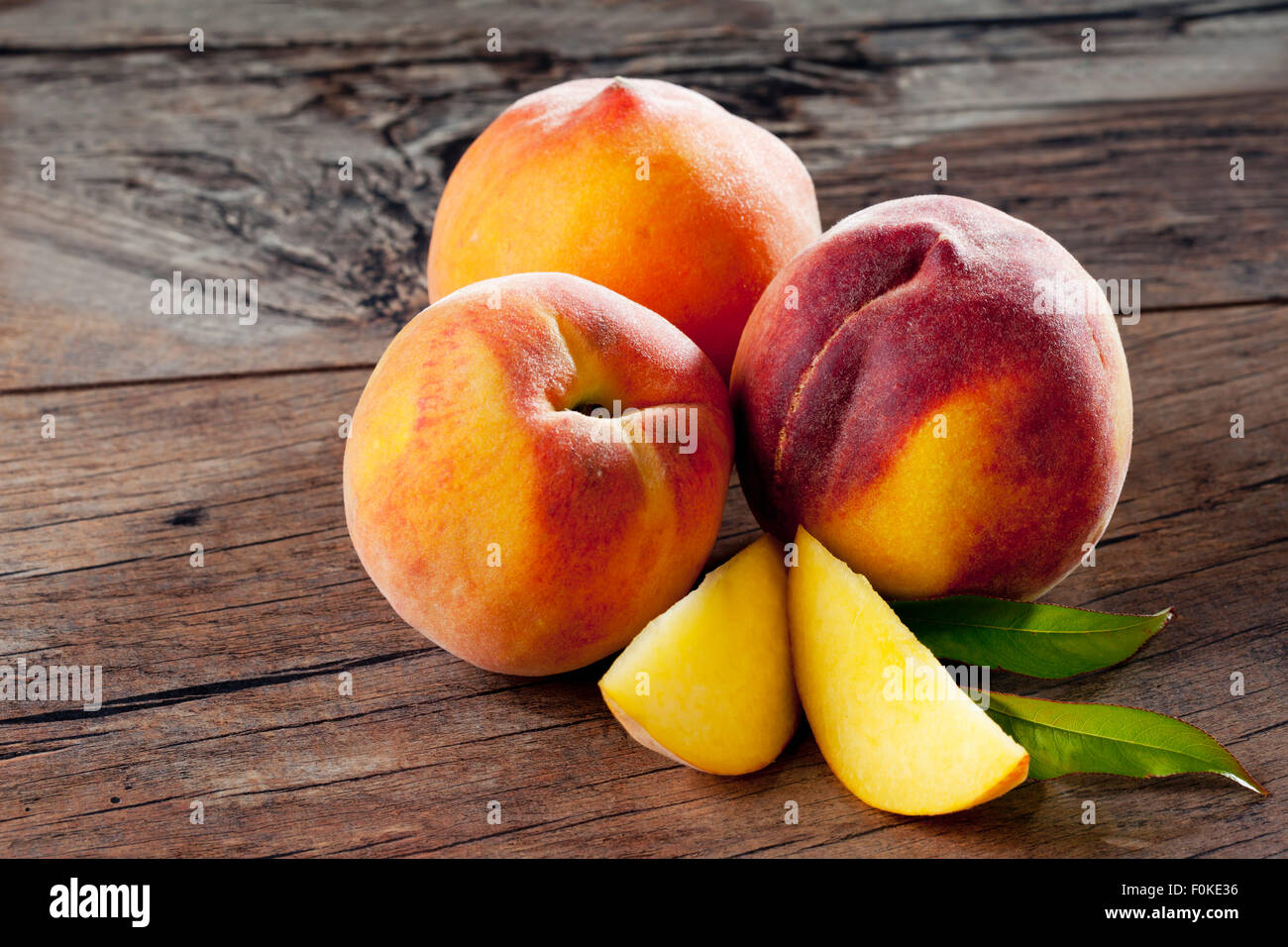 Whole peaches and slices of peach on wood Stock Photo - Alamy