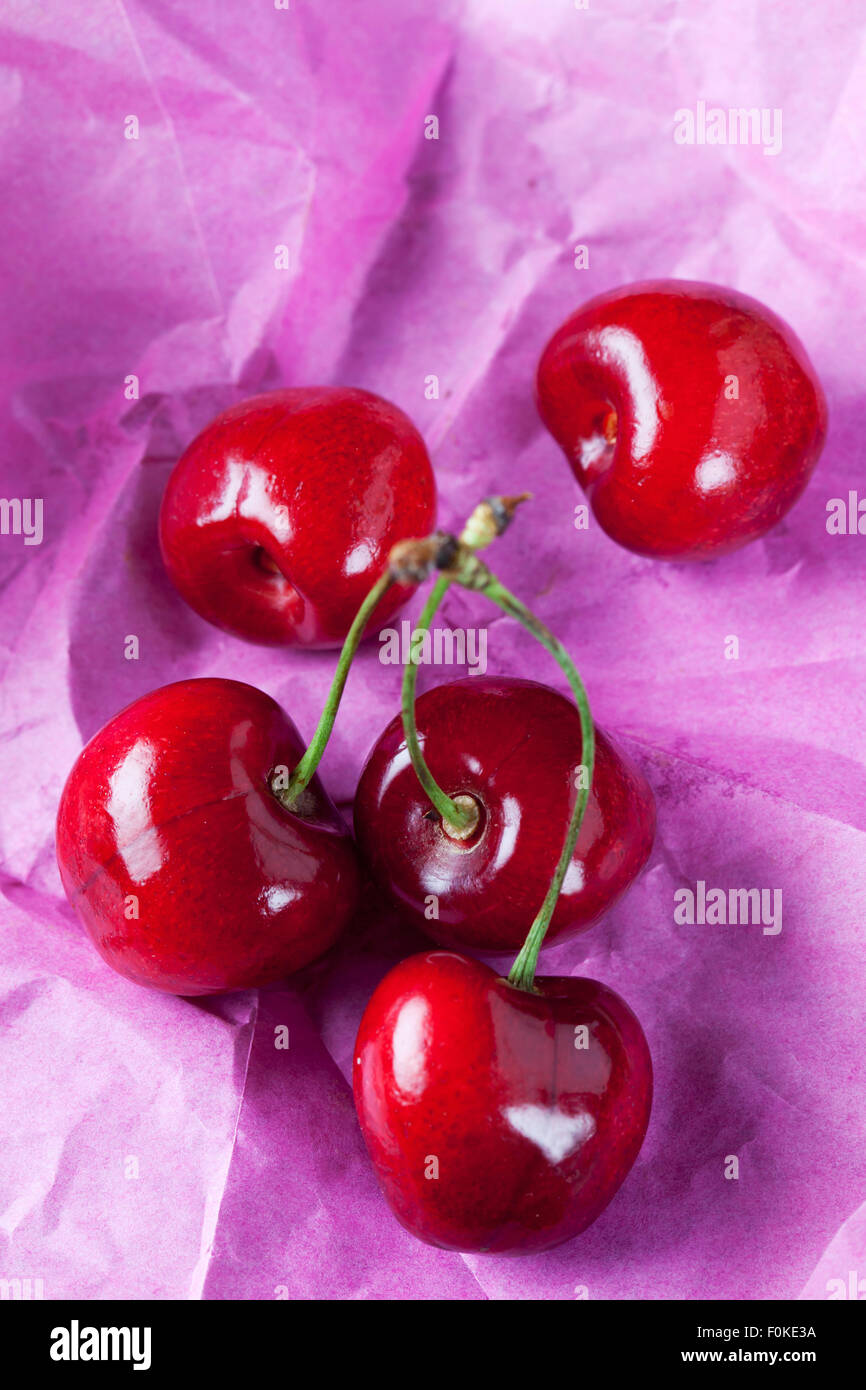 Five cherries on pink paper Stock Photo - Alamy