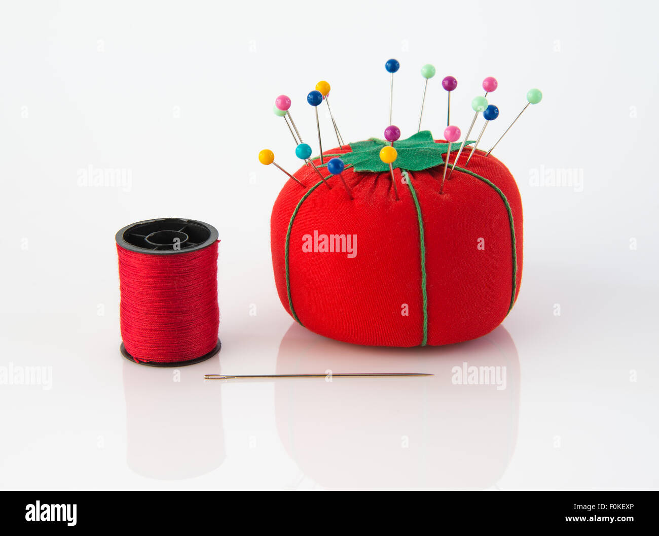Tomato pin cushion and thread needle Stock Photo - Alamy