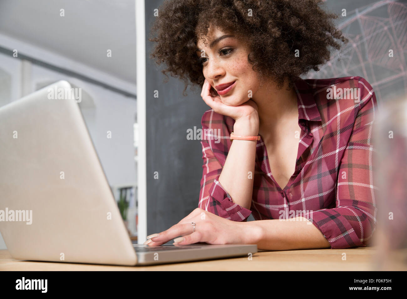 Young woman in office using laptop Stock Photo - Alamy