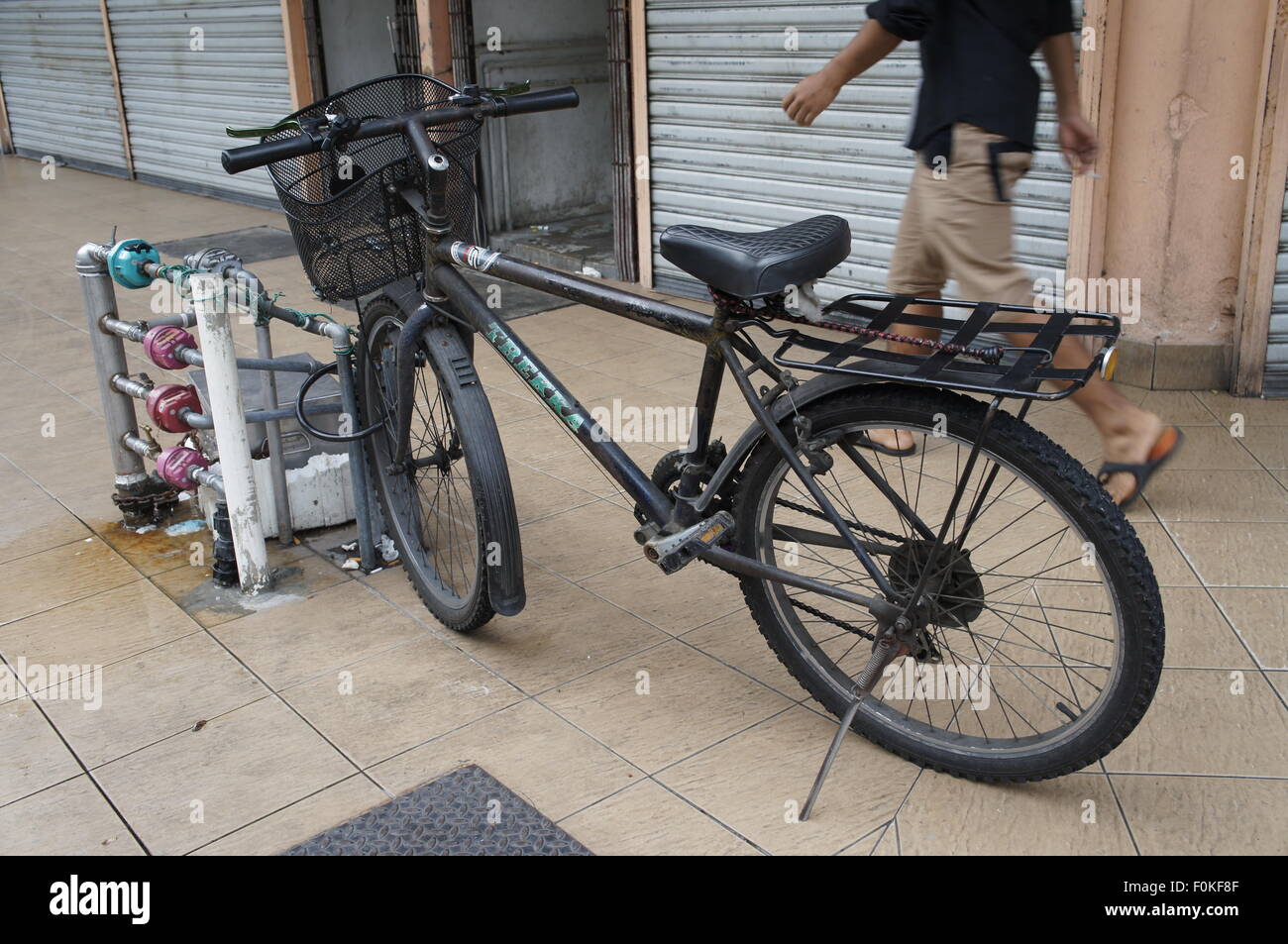 bicycle tied to water pipes on walk way Stock Photo - Alamy