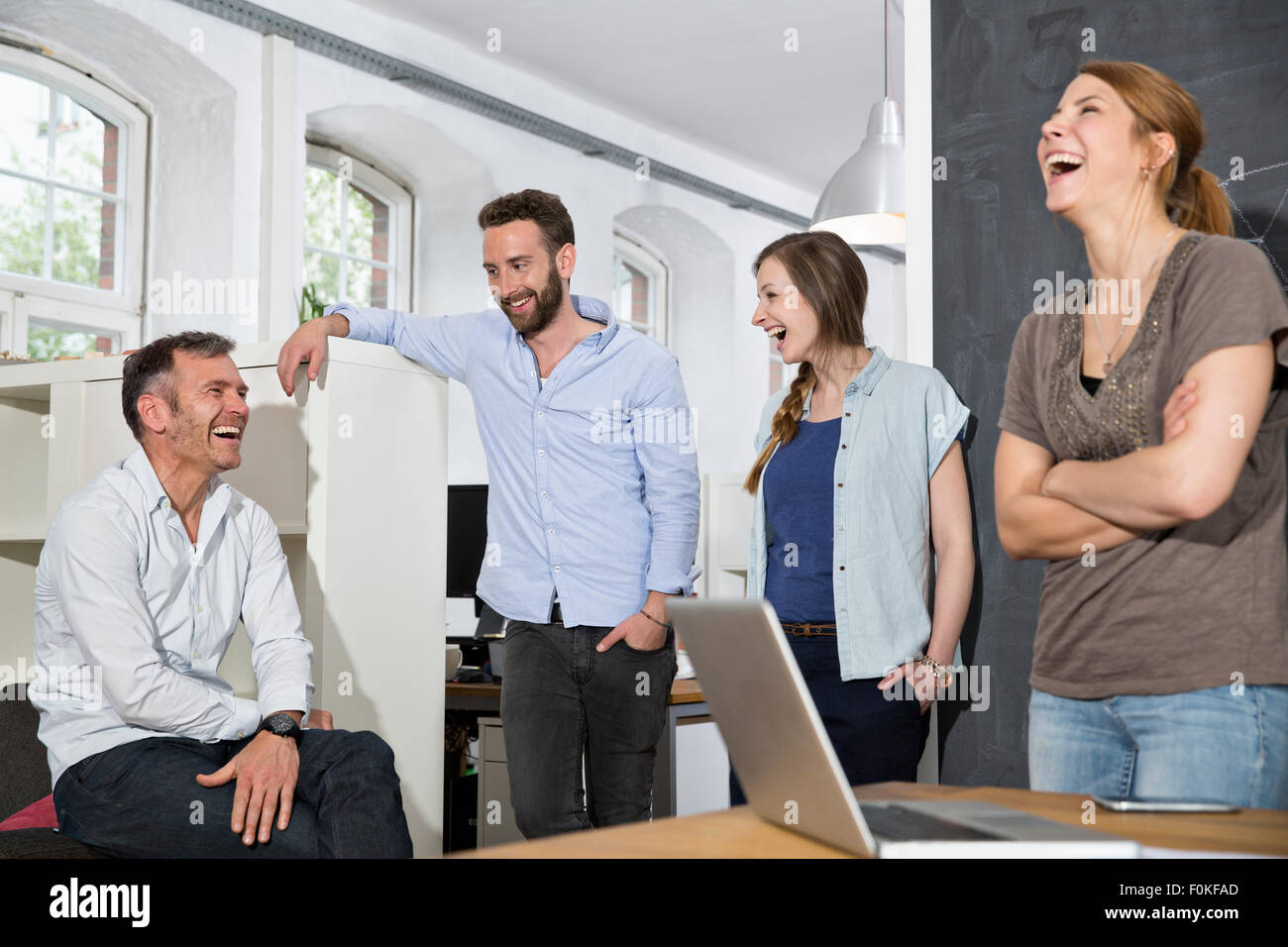 Colleagues laughing in office Stock Photo - Alamy