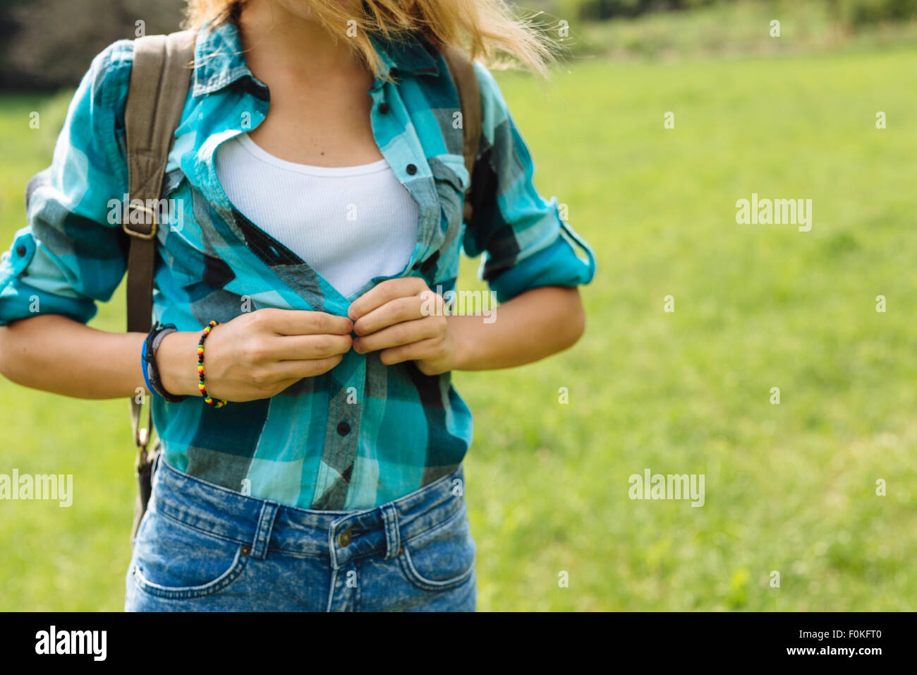 Teenage girl buttoning her shirt Stock Photo - Alamy