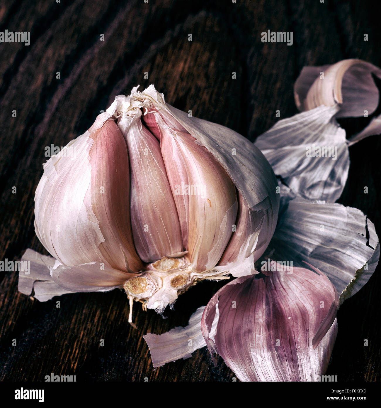 A head of garlic showing the cloves inside. Dark and rustic background ...