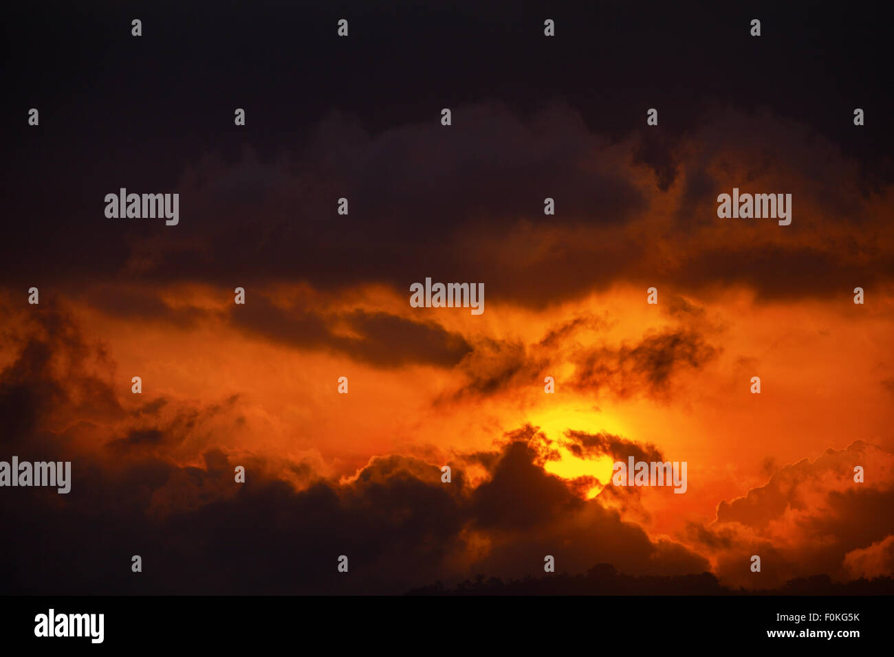 Bright orange ball of the sun, blazing with its final rays of light as ...