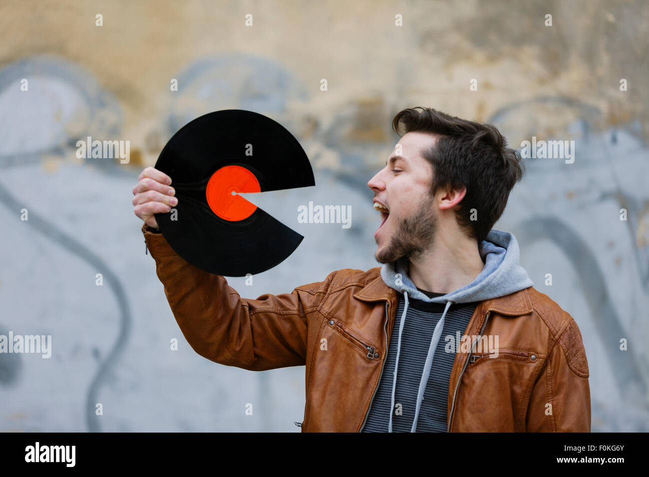 Young man holding broken record Stock Photo - Alamy