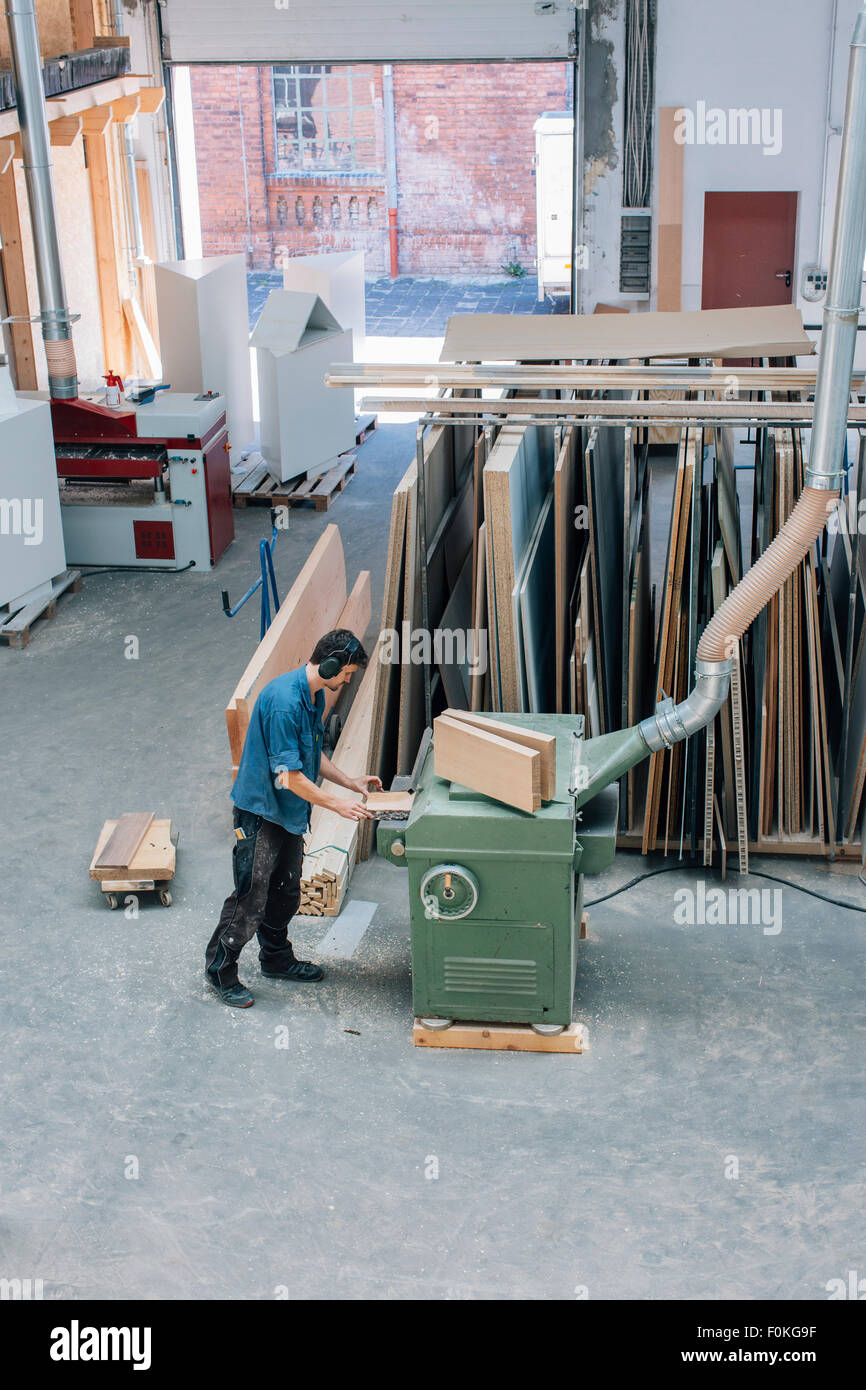 Carpenter working with planing machine in workshop Stock Photo - Alamy