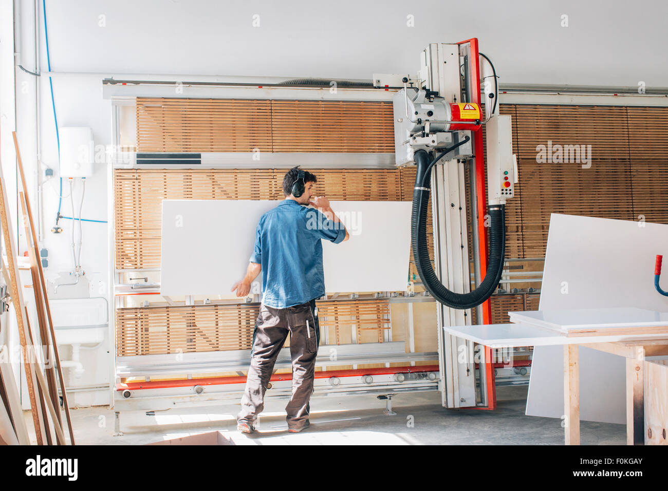 Carpenter cutting wood in workshop with machine Stock Photo - Alamy