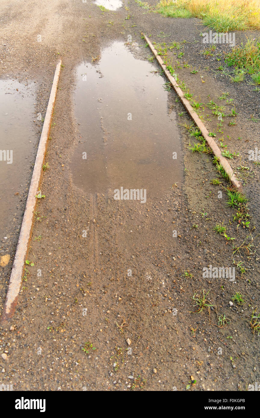 puddle on the old unused rusty railroad track Stock Photo - Alamy
