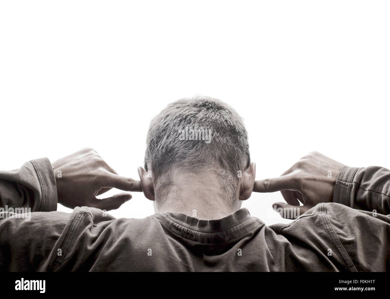 Young man turned back and has his fingers in his ears, against white ...