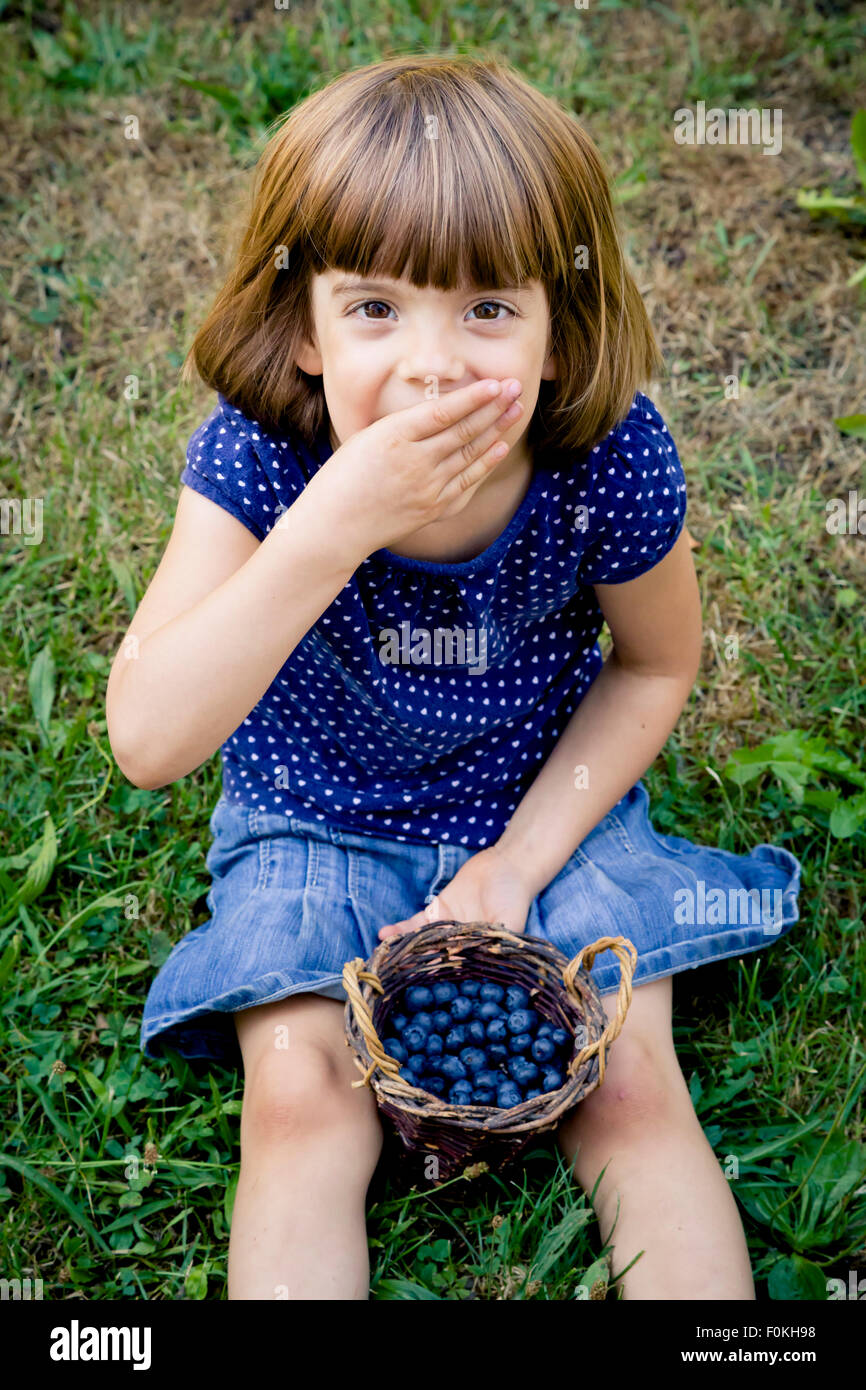 Little girl eating blueberries Stock Photo - Alamy