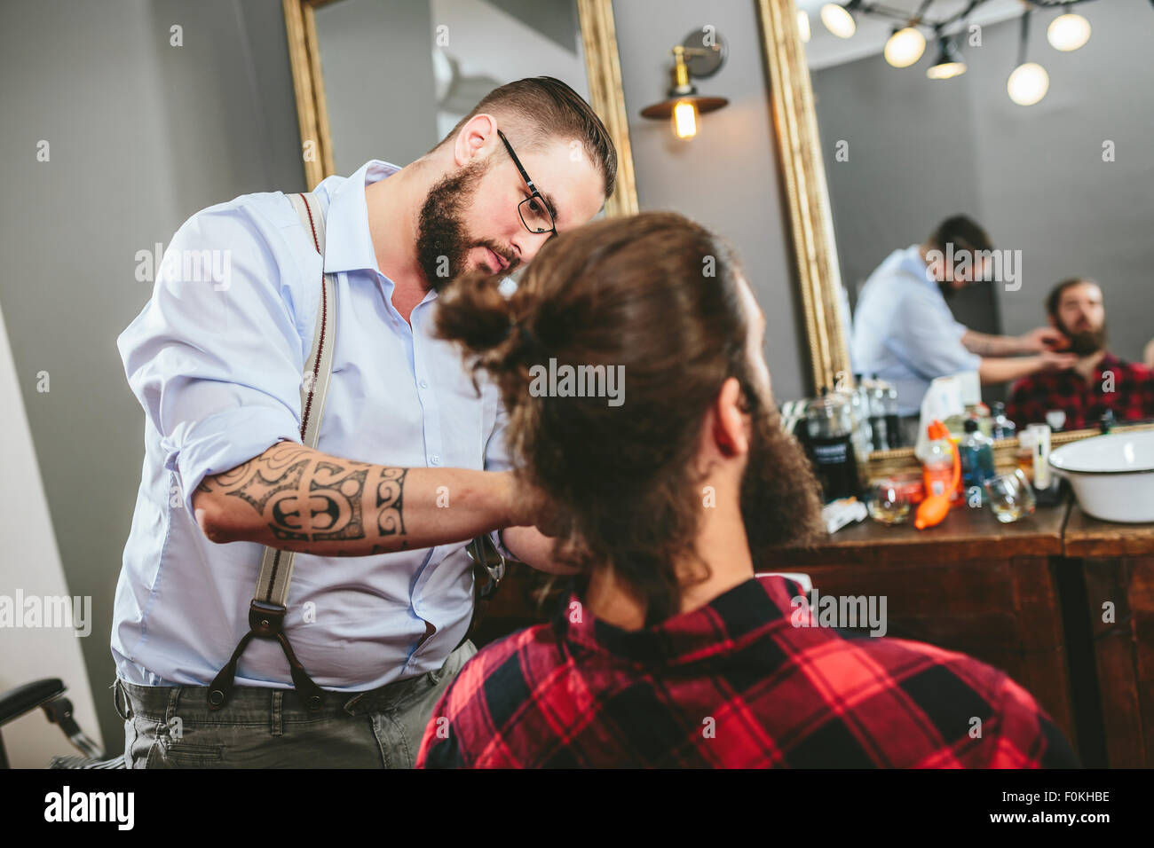 Barber brushing beard of a customer Stock Photo - Alamy