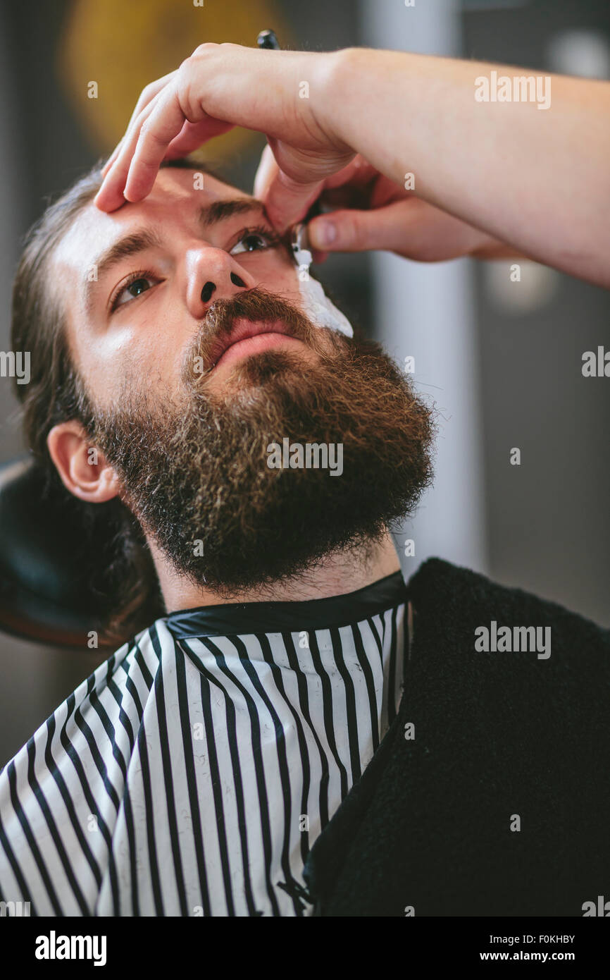 Man with full beard getting a shave at the barber Stock Photo - Alamy