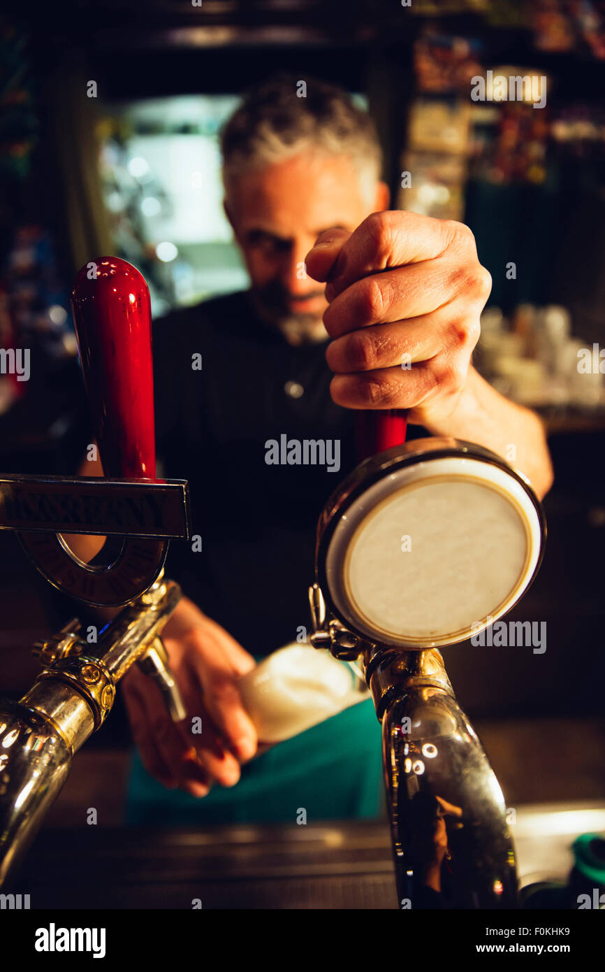 Hand of a man tapping beer in an Irish pub Stock Photo - Alamy