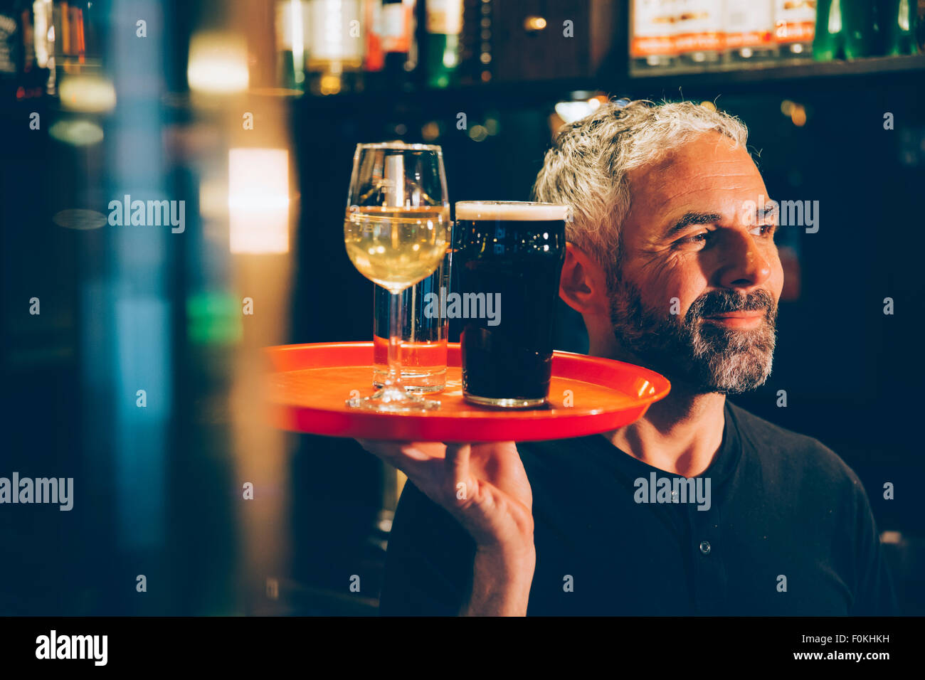 Waiter holding traywith beverages in an Irish pub Stock Photo - Alamy
