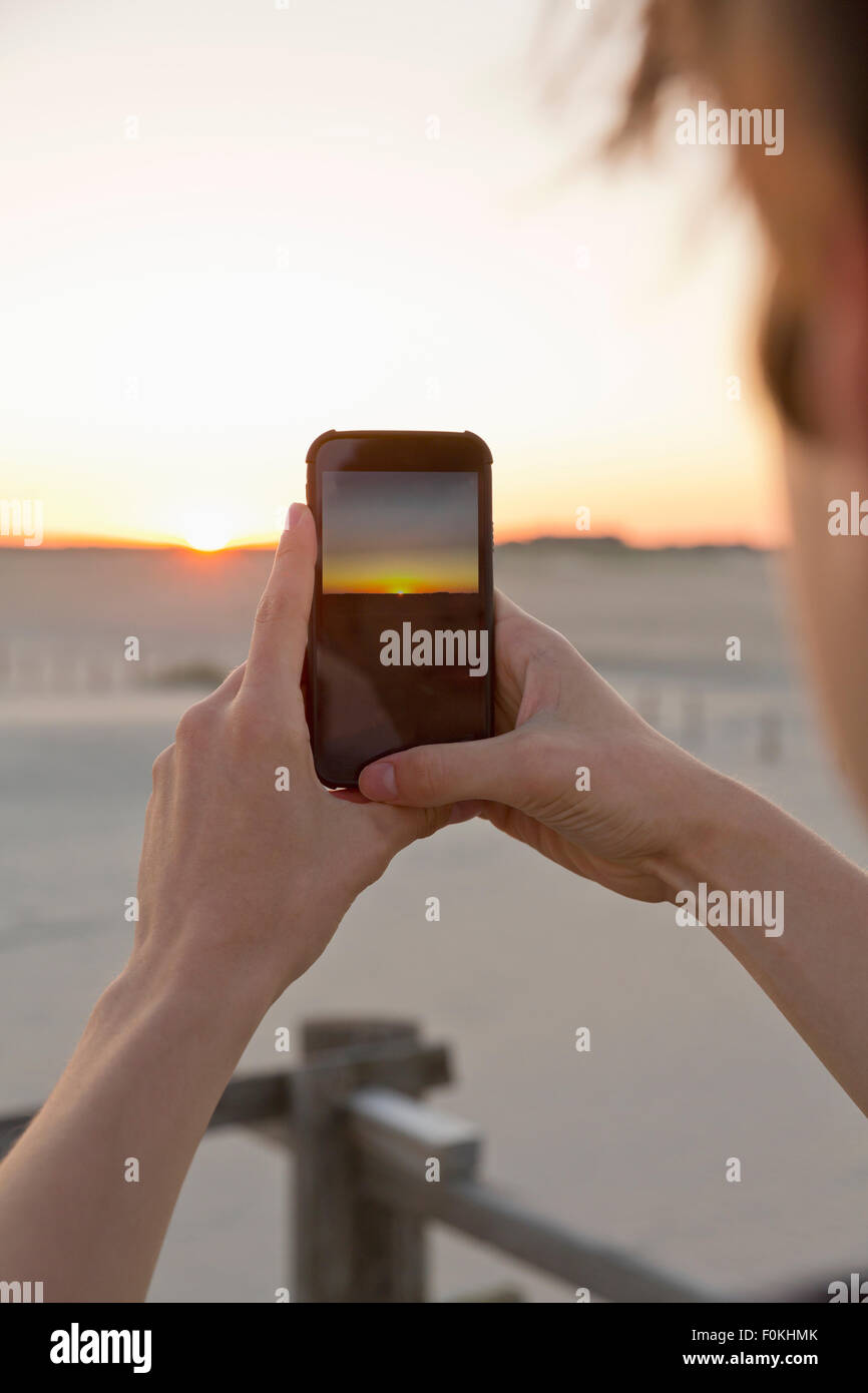 Teenage boy taking picture of sunrise with his smartphone Stock Photo ...