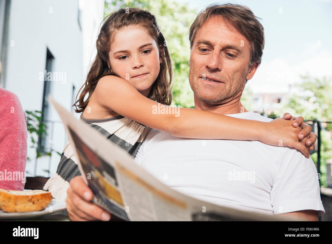 Father and daughter reading newspaper at breakfast table Stock Photo ...
