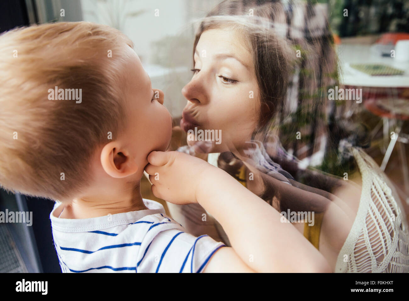 Mother and son kissing through a window Stock Photo - Alamy
