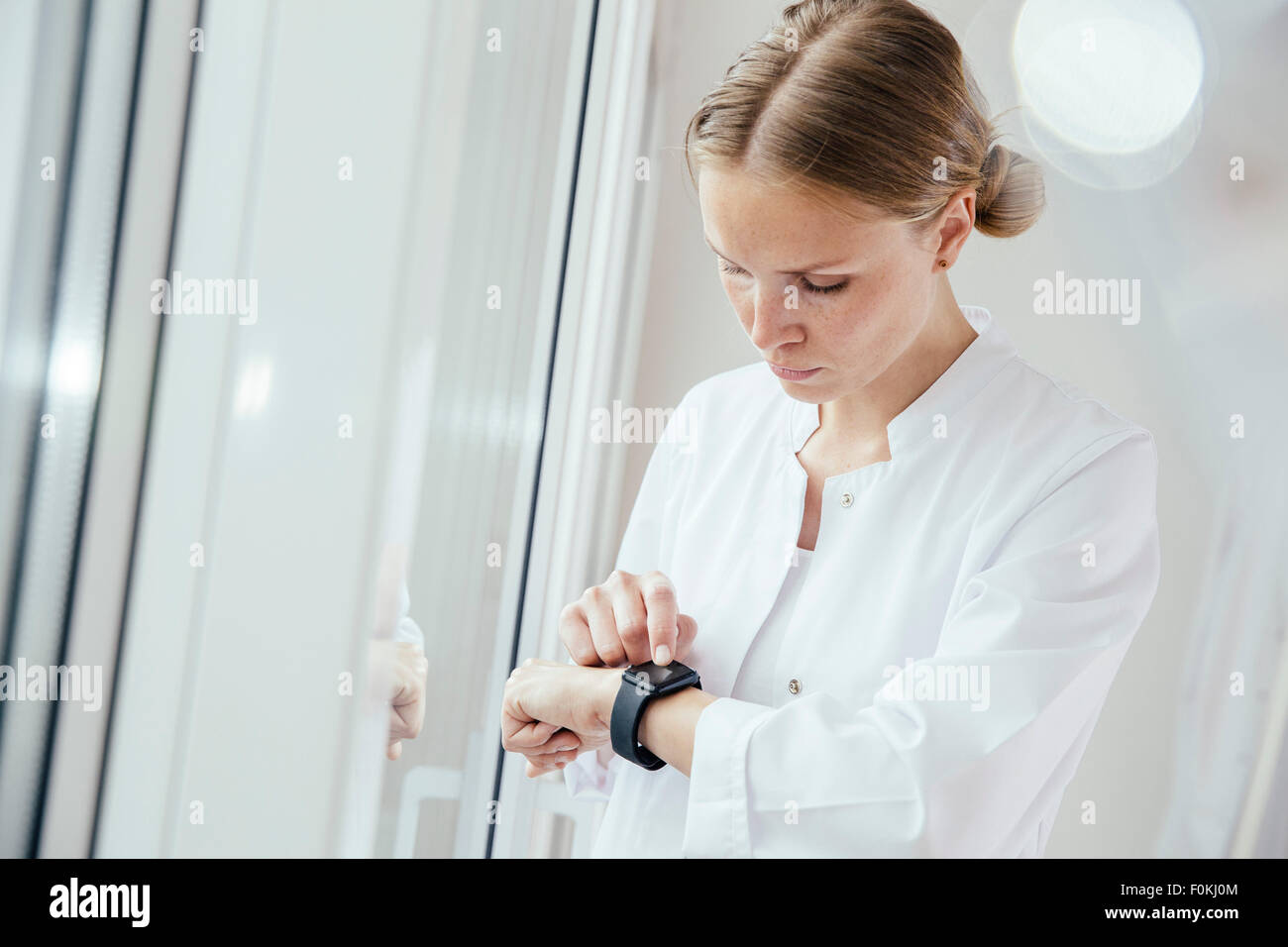 Female doctor looking on her smart watch Stock Photo - Alamy